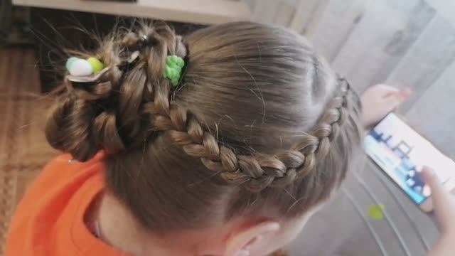 Прическа с пучком, плетёным в виде цветов.