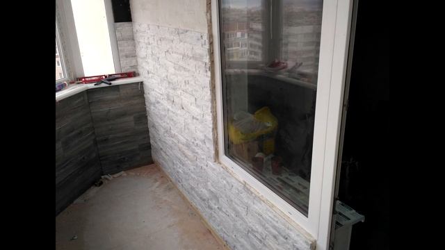 Отделка балкона декоративным камнем и ламинатом. Подсветка под подоконником.