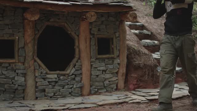 Примитивное убежище для бушкрафта в тропическом лесу - каменная крыша и каменная стена