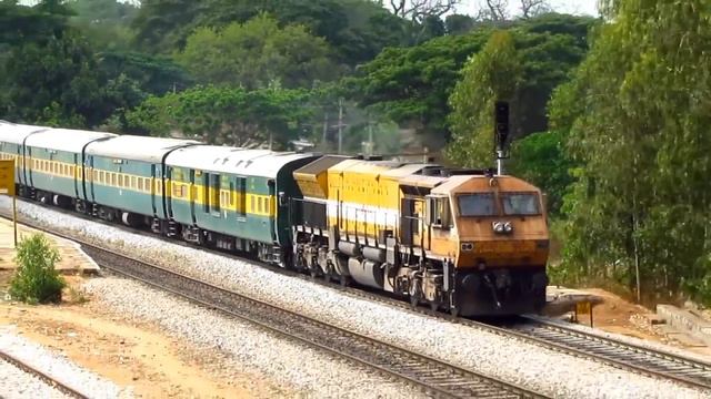 Громкий Индийский поезд проезжает станцию и приветствует пассажиров