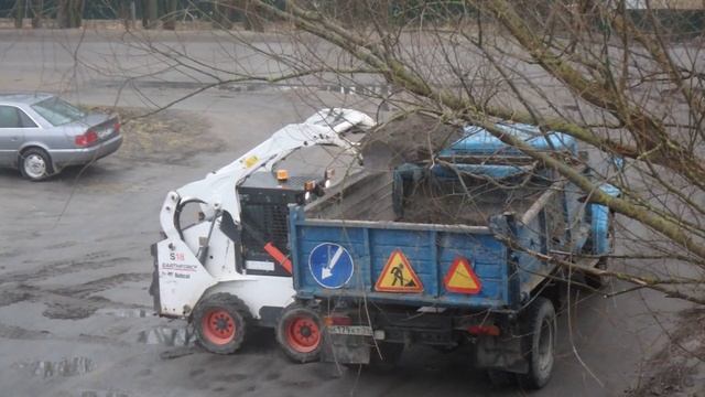 Погрузчик Bobcat загружает Зил