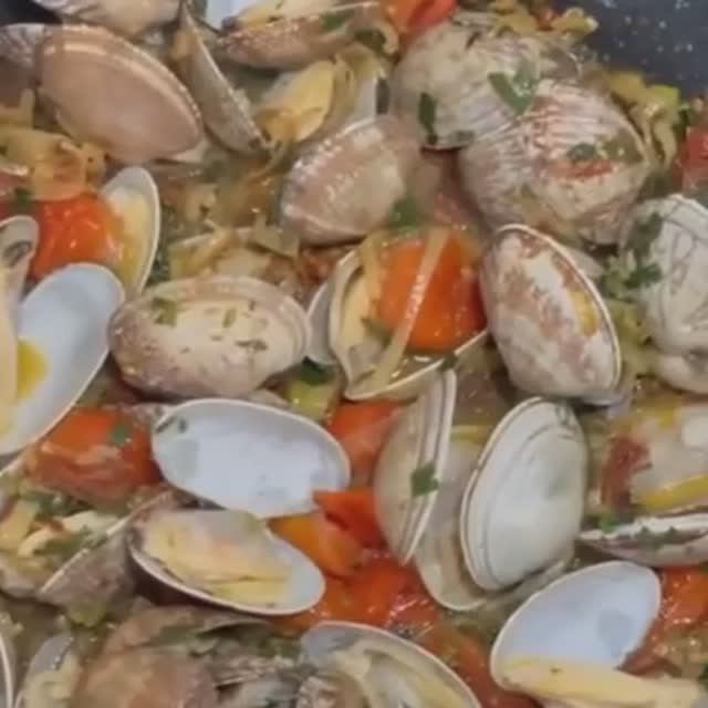 Вонголе в раковинах с томатами в белом вине