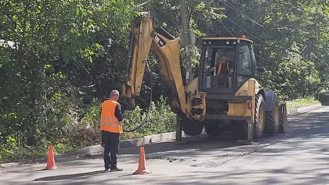 Работает спецтехника -  долбит старый асфальт автодороги