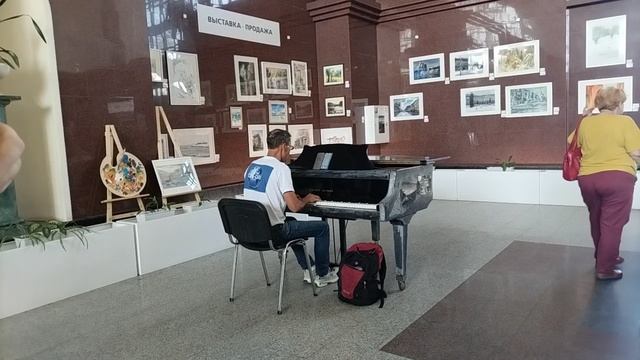 Рояль на вокзале Новосибирск-Главный. Мужчина играет на вокзале.