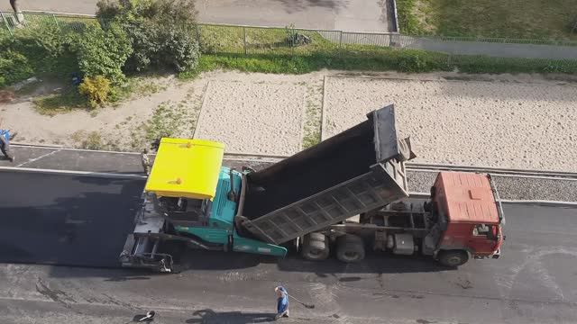 Асфальтоукладчик и самосвал ремонтирует придомовую дорогу