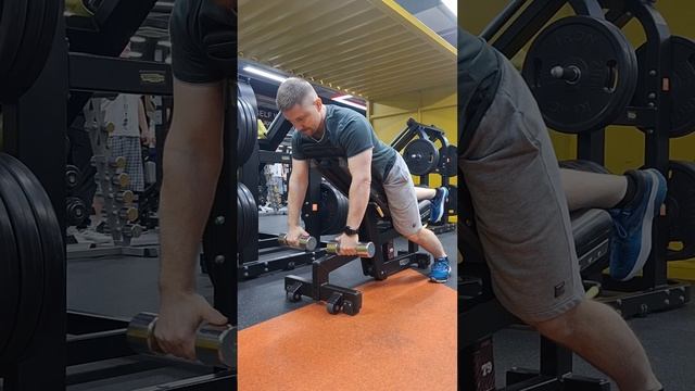 Пугало с гантелями лёжа животом на наклонной скамье