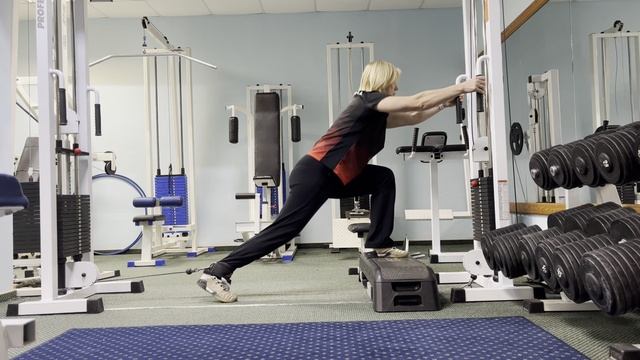 Махи бедром вперед в кроссовере стоя на степе с нижним блоком