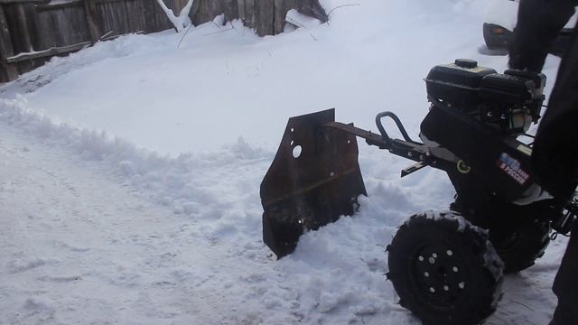 Мотоблок чистит снег.