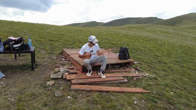 Парень играет на хомысе на горе Кюн таг. Хакасия