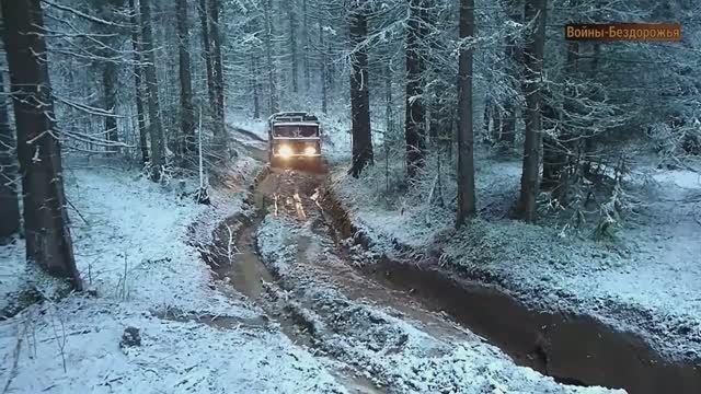 4x4 Внедорожные старые грузовики ГАЗ 66 на дороге в снегу и застрявшие в грязи.