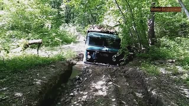 4x4 Старые советские грузовики ГАЗ 66 грузят дрова в грязь.