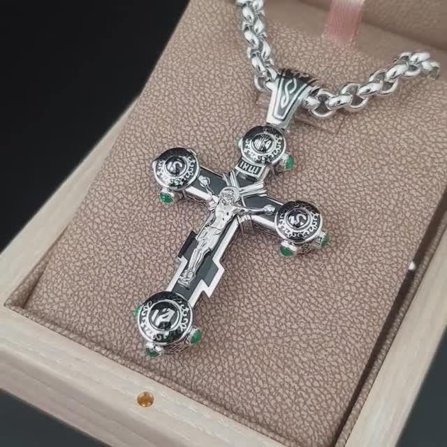 Нательный крест из белого золота с черной эмалью, украшенный изумрудами
