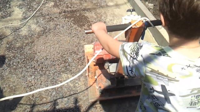 Сын помогает трамбовать виброплитой )))