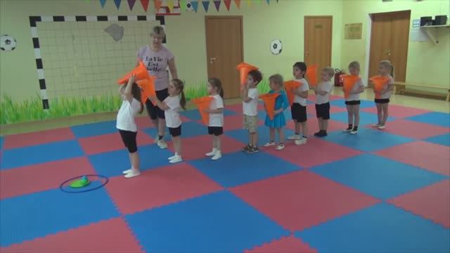 Передаем мячик из конуса в конус над головой