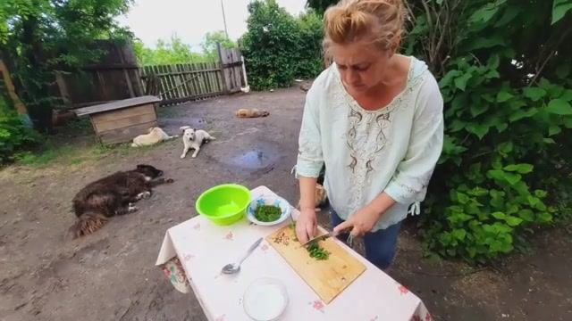 Деревенская женщина, готовит чебака на костре. Жизнь в деревне