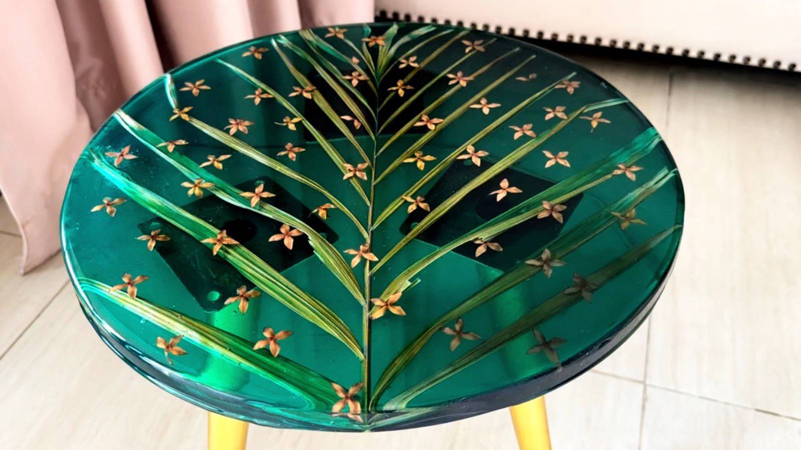 Зеленый стол из эпоксидной смолы с листом пальмы.