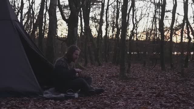 BERTRAN  - canvas tent and wood stove next to large lake, making firewood, cooking etc.