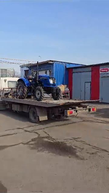 Купленный трактор выезжает с фирмы в сторону моего участка
