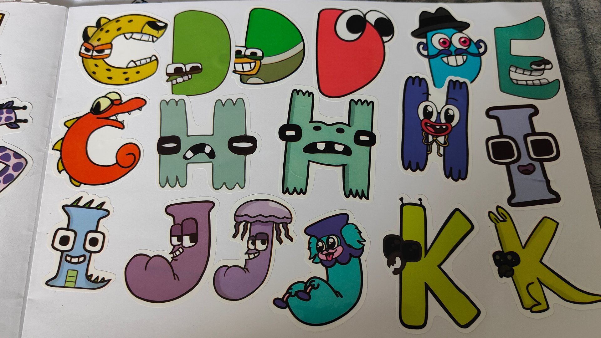 рассматриваем детский альбом с наклейками алфавита лор, наклейки alphabet lore для детей