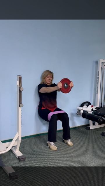 «Стульчик» с удержанием диска в поднятых вперёд руках и разведением бёдер с резинкой