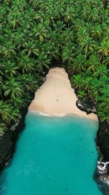 Этот пляж в Сан-Томе и Принсипи славится своей кристально чистой водой и белоснежным песком