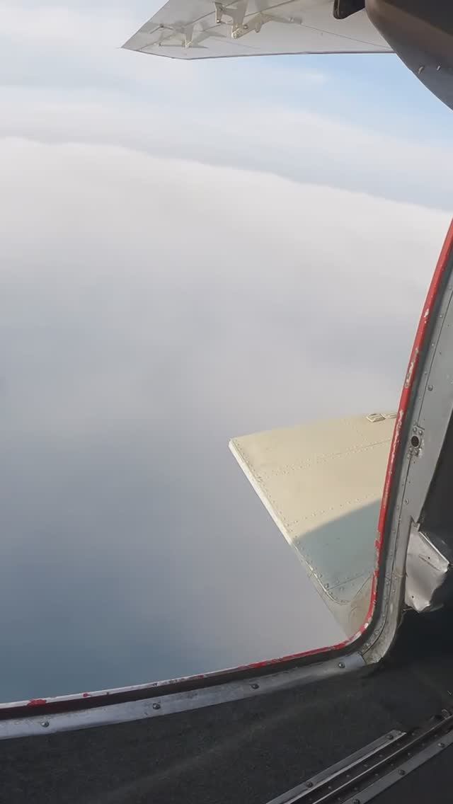 По краю облаков через открытую дверь самолета