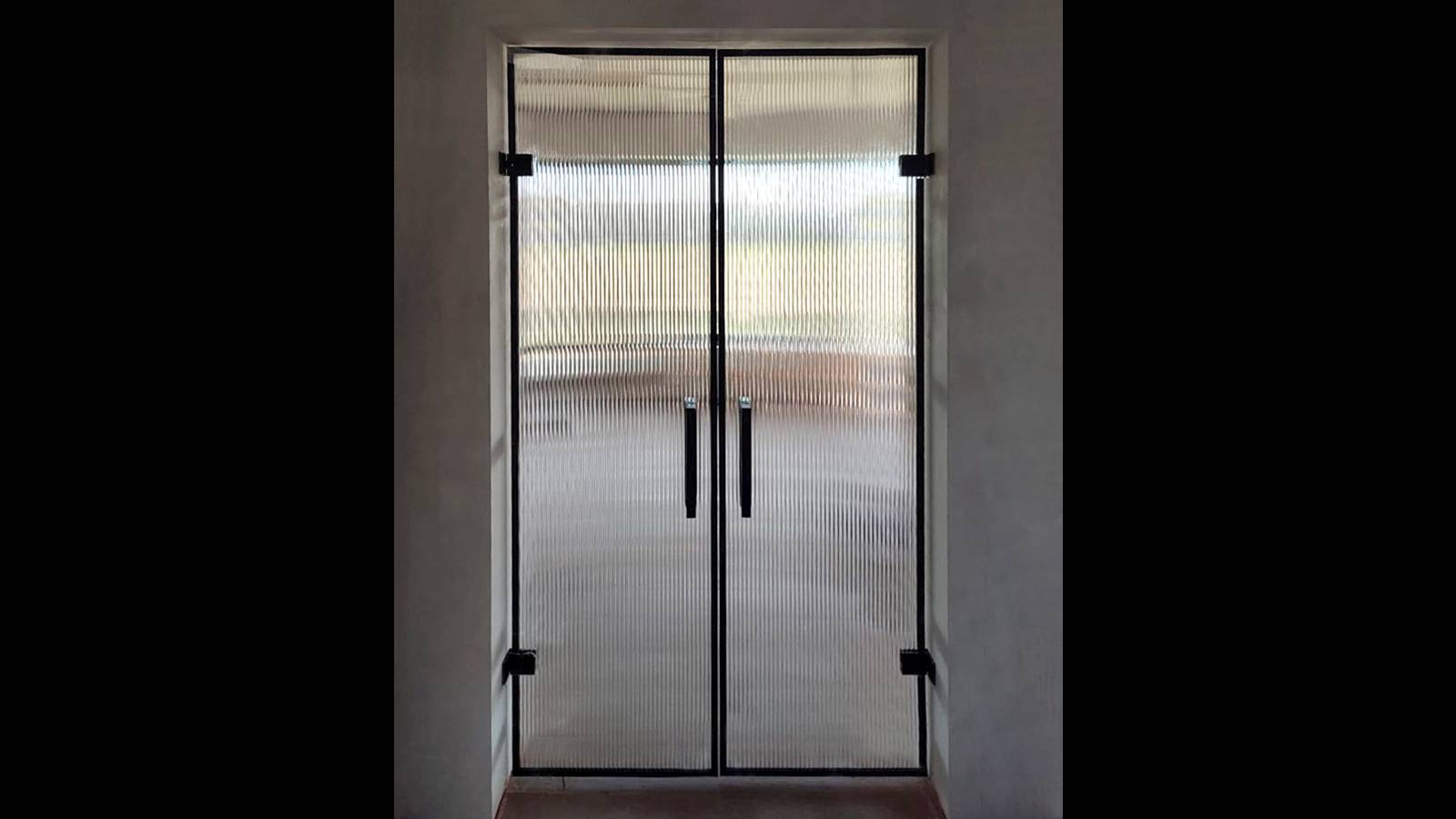 Стеклянная распашная дверь с черной фурнитурой