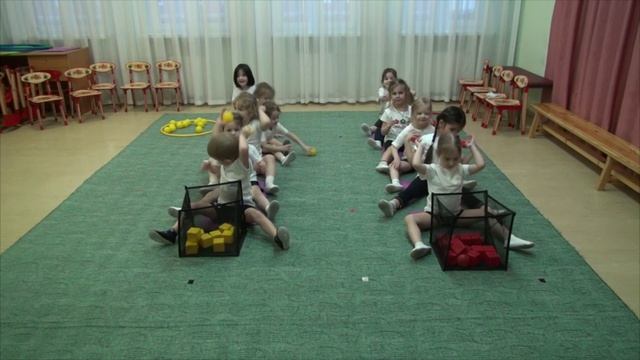 Играем с детьми. Передаем кубики назад сидя на полу.