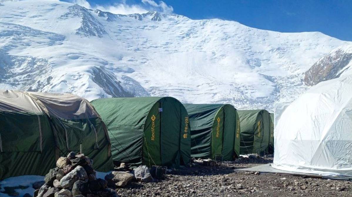 Гид Клуба 8000 Андрей Березин представляет палатку глэмпингового типа в Лагере 1 под пиком Ленина