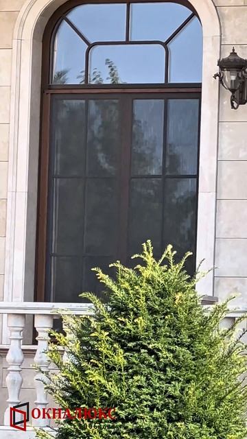 В доме с окнами со шпросами из евробруса установили сдвижные москитные сетки плиссе в цвете каштан.