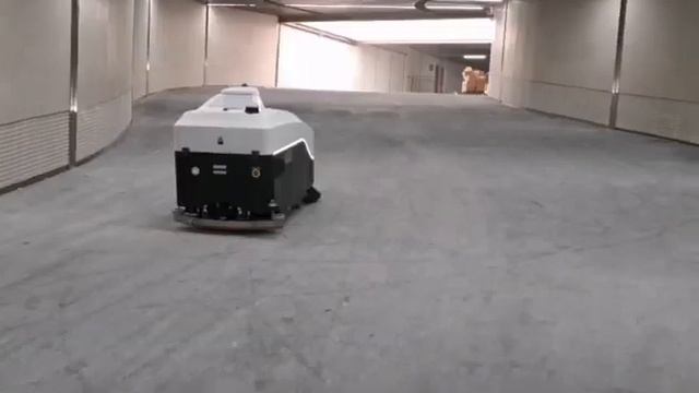 Kokobots S95 универсальный подметально-поломоечный робот уверенно двигается по пандусу паркинга.