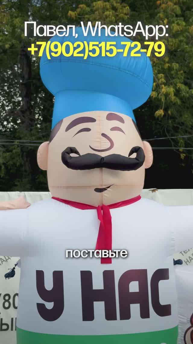 Надувной повар машет рукой.