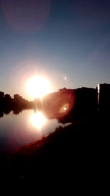 Закат. Солнце красиво блестит за домами.