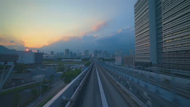 Япония. Поездка на поезде в сумерках вдоль Токийского залива