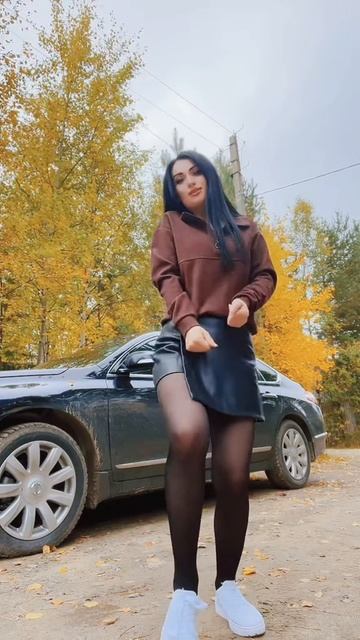 Красотка танцует возле машины в колготках под музыку ножки в нейлоне