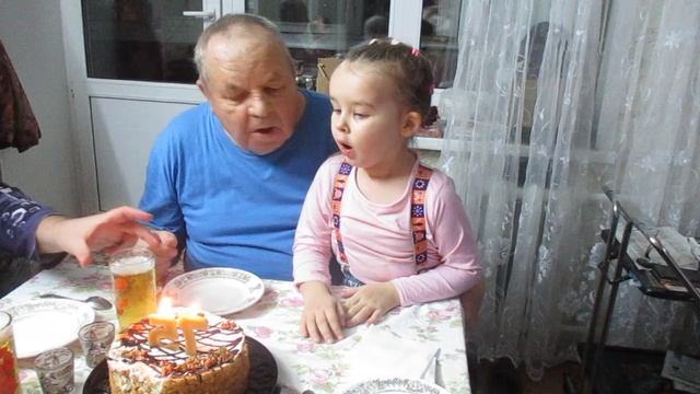 Полина и прадед задувают свечи.