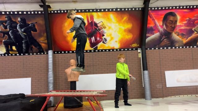 Соскок назад с батута с "ударом" палкой под ногами