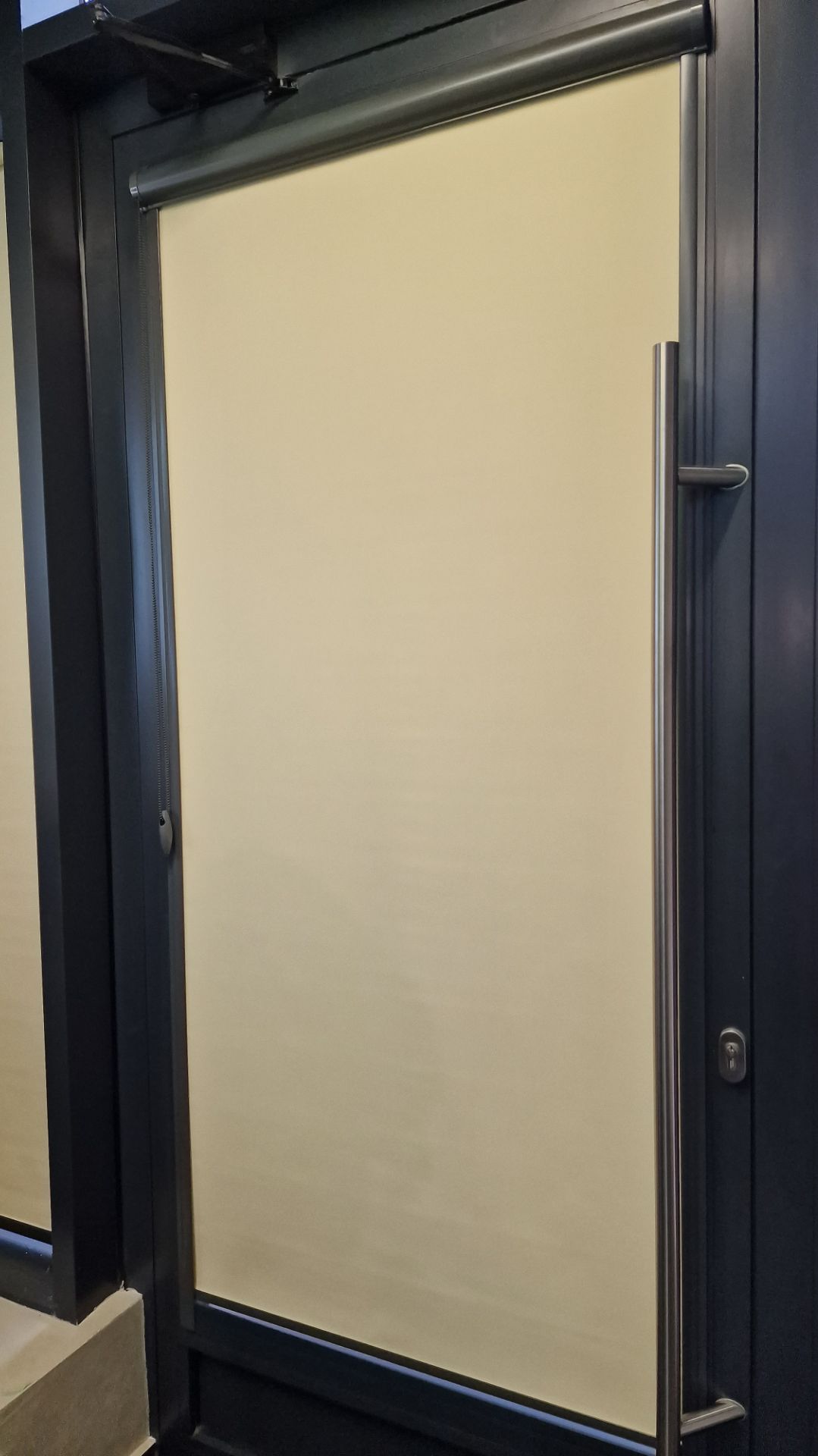 Кассетная рулонная шторка уни1 на дверь. Ткань Респект блэкаут светло-бежевый.