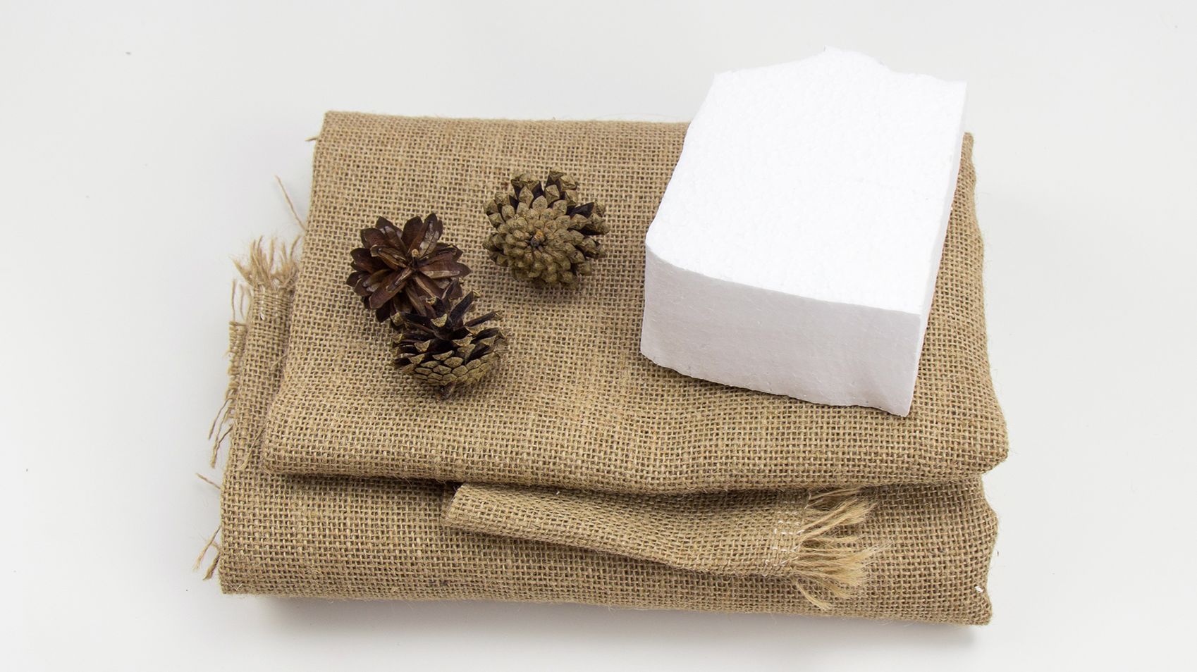 Простая идея: из мешковины, шишек и пенопласта сделали новогоднюю поделку.