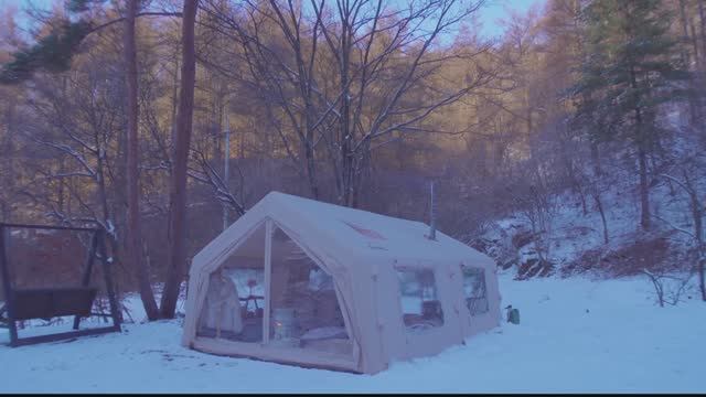 Надувная палатка в заснеженной горе с теплым камином