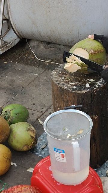 сливает молоко из кокоса