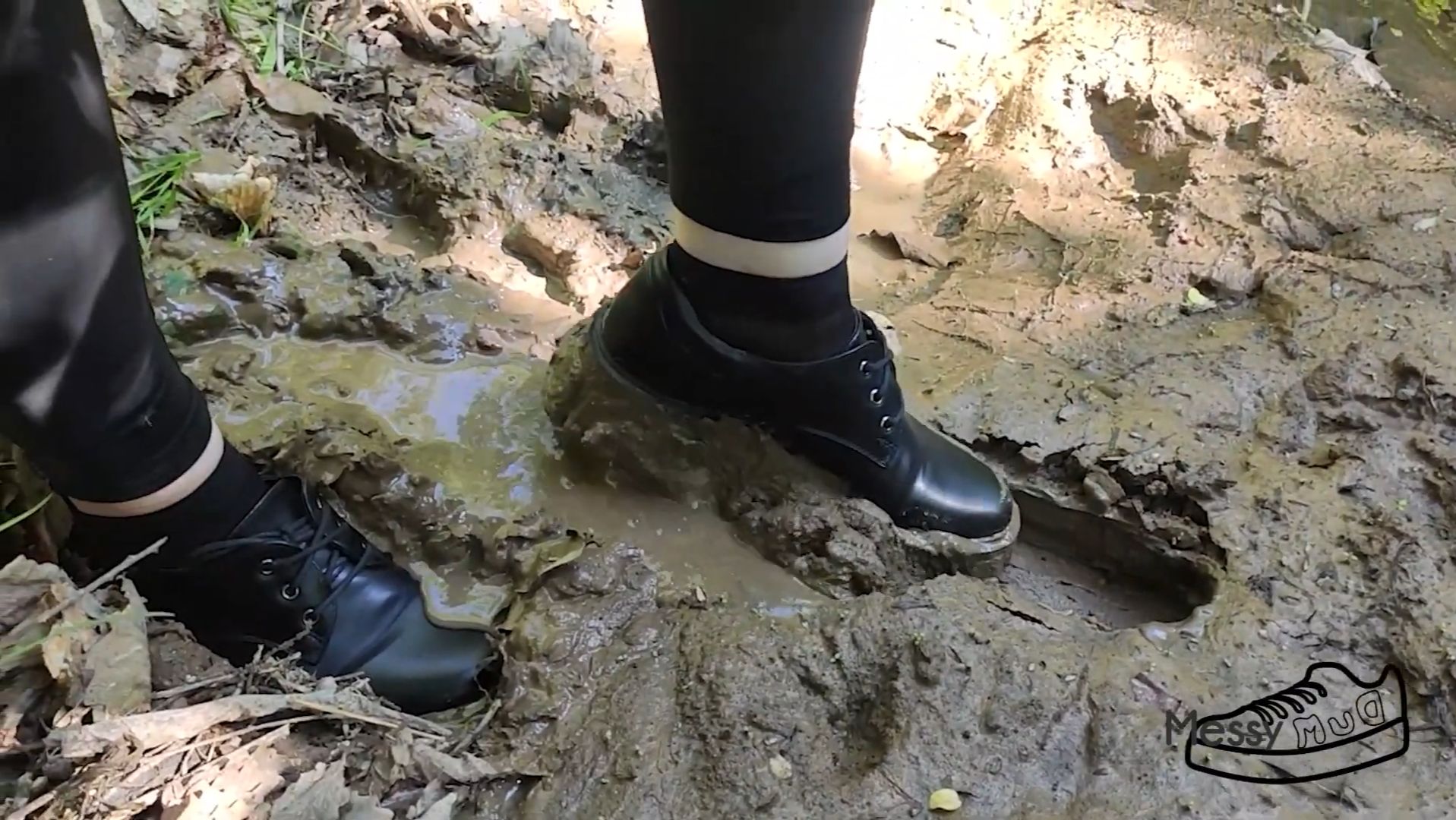 Девушка в чёрных туфлях ходит по грязи