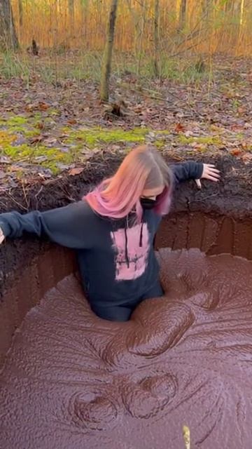 Девушка в леггинсах и розовых носочках в грязи