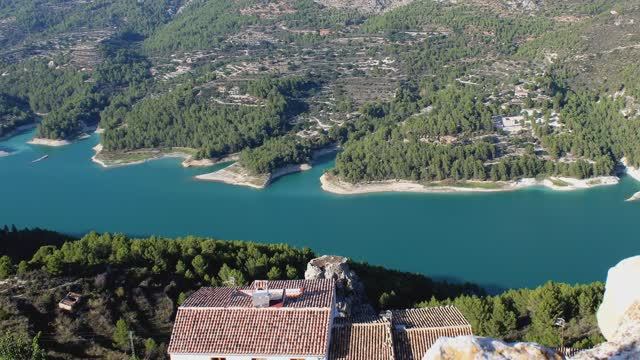 Замок Гуадалест в Испании на скале с видом на изумрудные воды озера - популярный и любимый туристами
