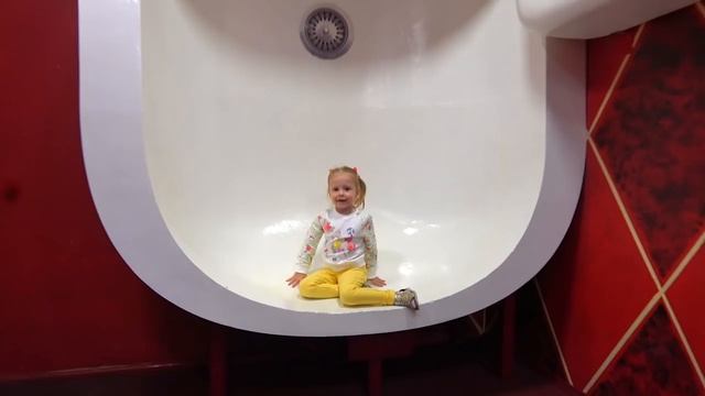 Настя играет на красочных детских площадках