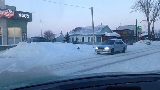 Морозное утро в городе. Автомобили и смешные вывески на магазине