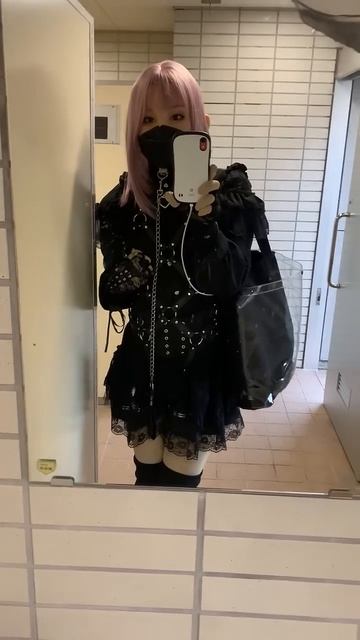 Девушка в кигуруми-маске и готично-фетишном прикиде делает селфи