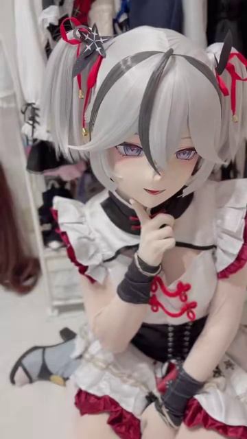 Миленькая кигуруми-кукла сидит перед камерой на коленях