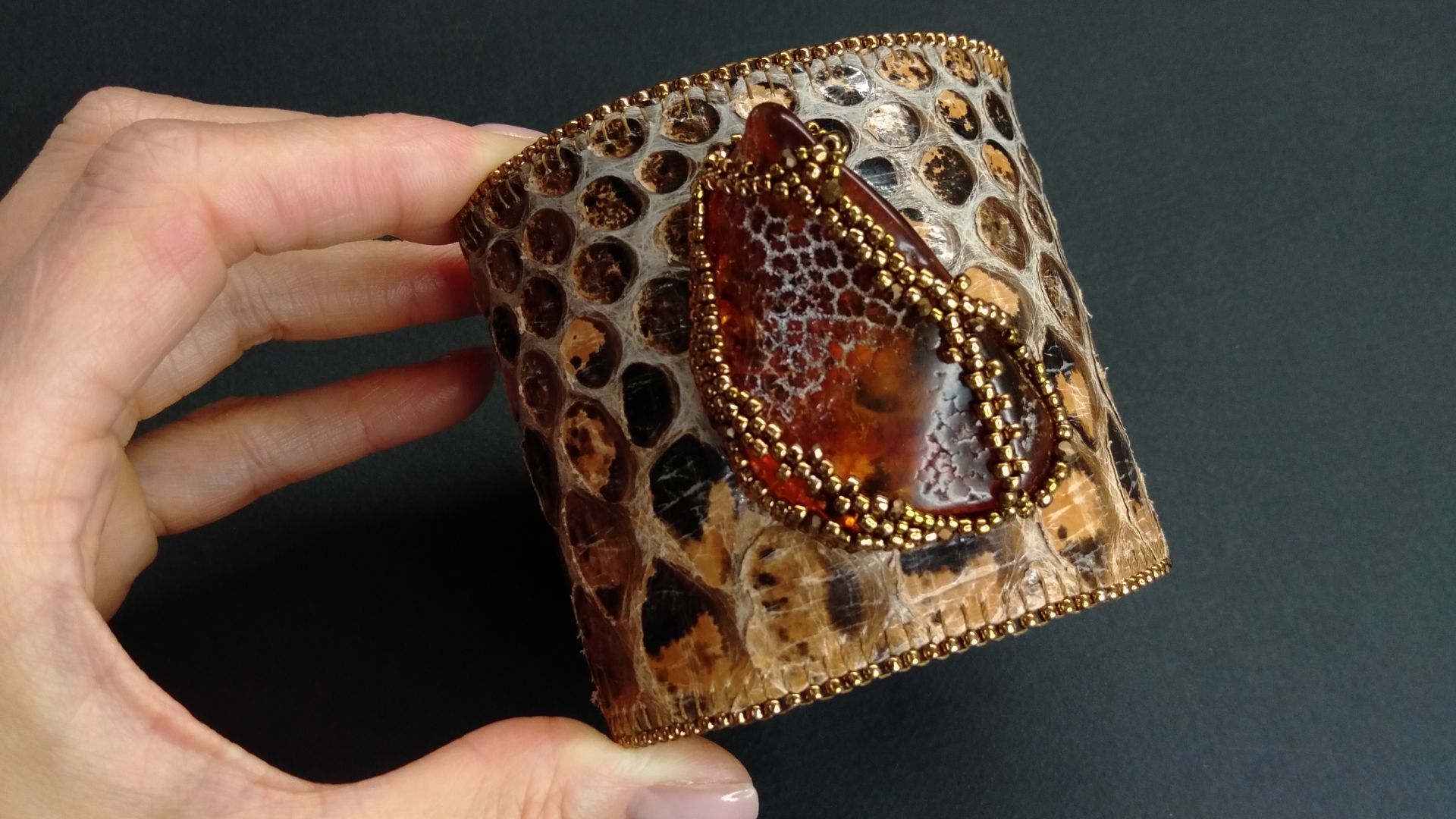 Широкий браслет из кожи питона с янтарем.