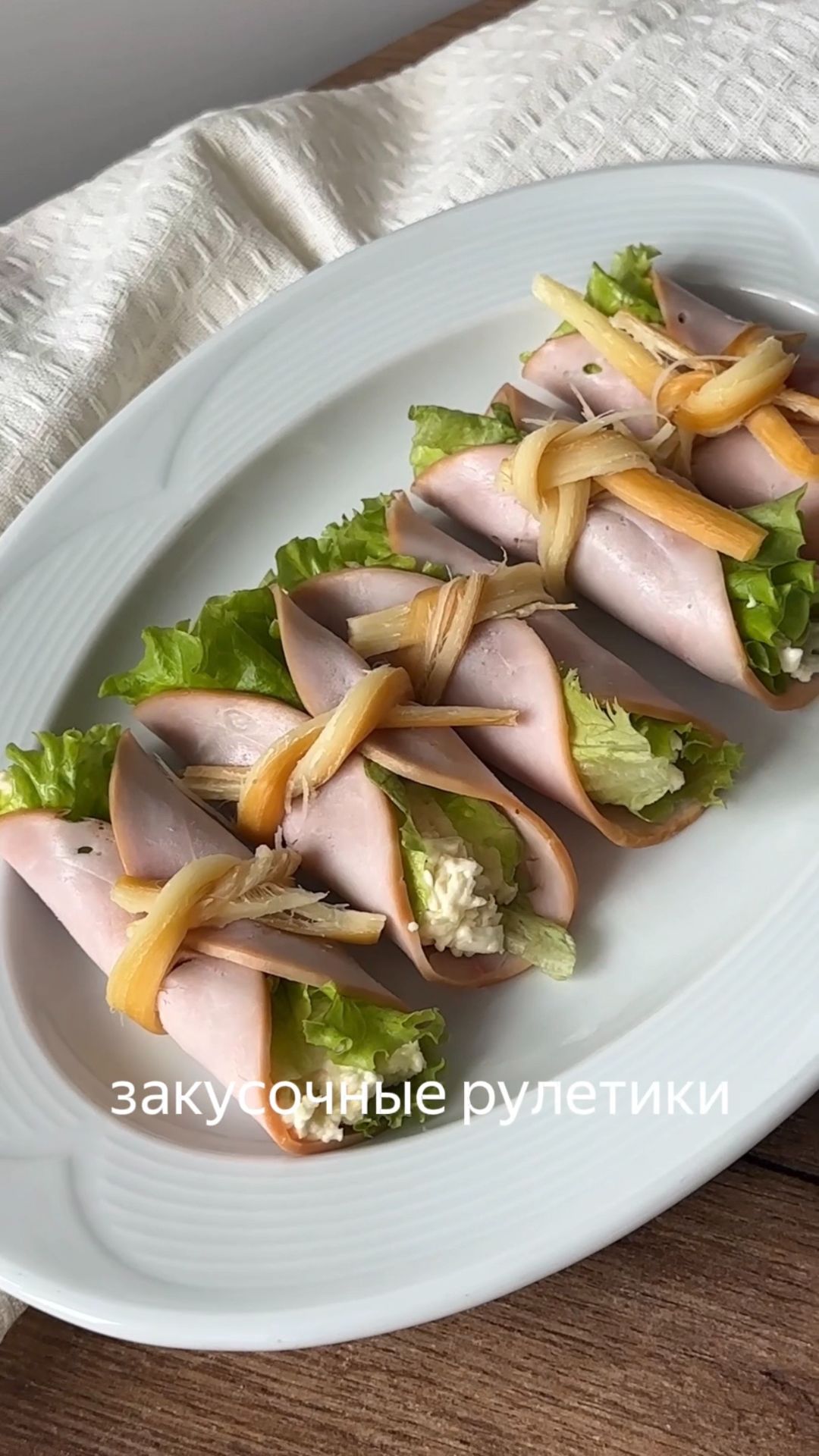 Рулетики из ветчины с острым сыром—аппетитная закуска, которая станет украшением праздничного стола.